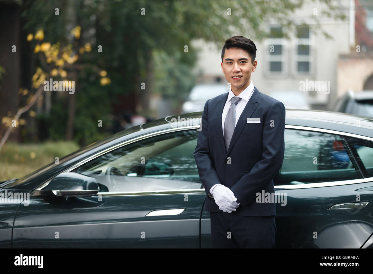 The young boy standing in front of the car Stock Photo - Alamy
