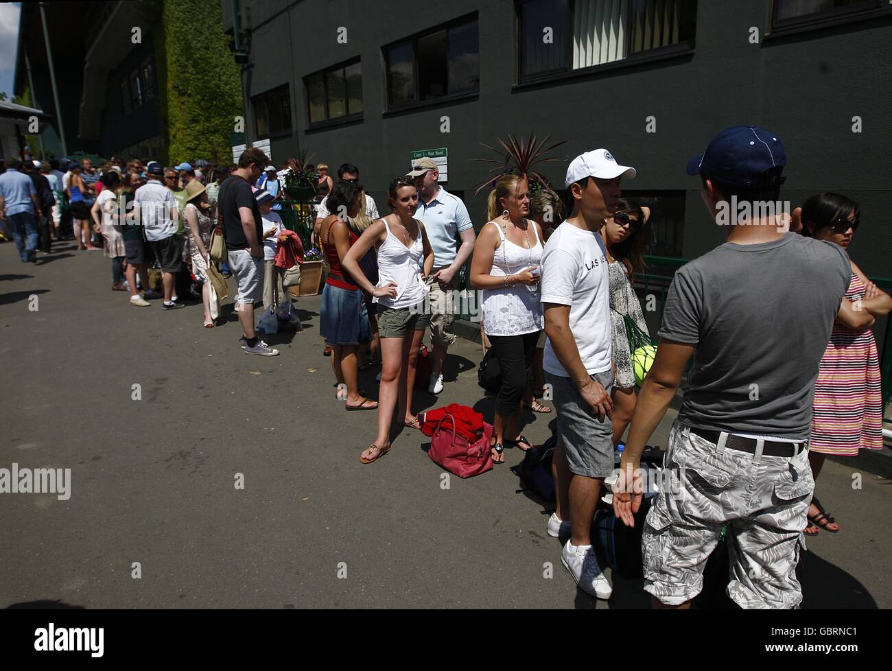 Tennis fans queue outside Court 3 during the Wimbledon Championships ...