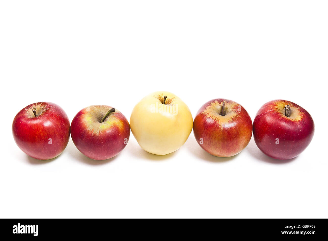 Single yellow apple in the middle of group of red apple. Group of juicy ...