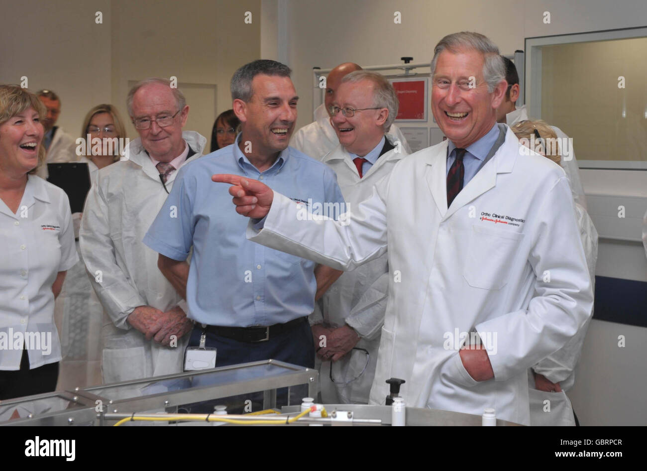 The Prince of Wales shares a joke with staff in the dispensing area at ...