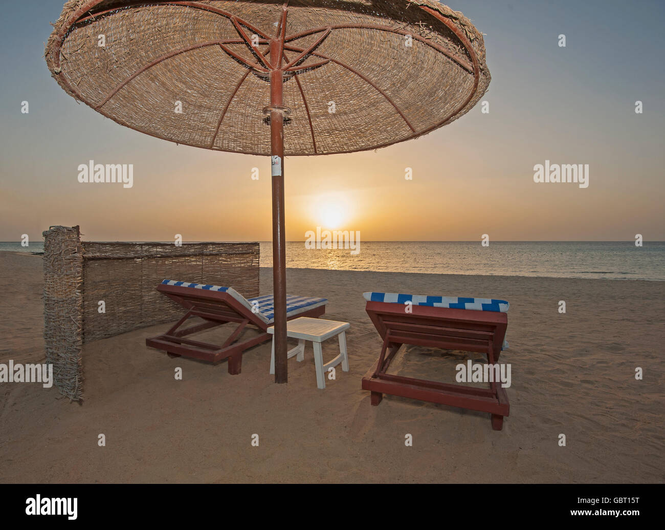 Sunrise at dawn over ocean at tropical hotel resort beach with sun ...