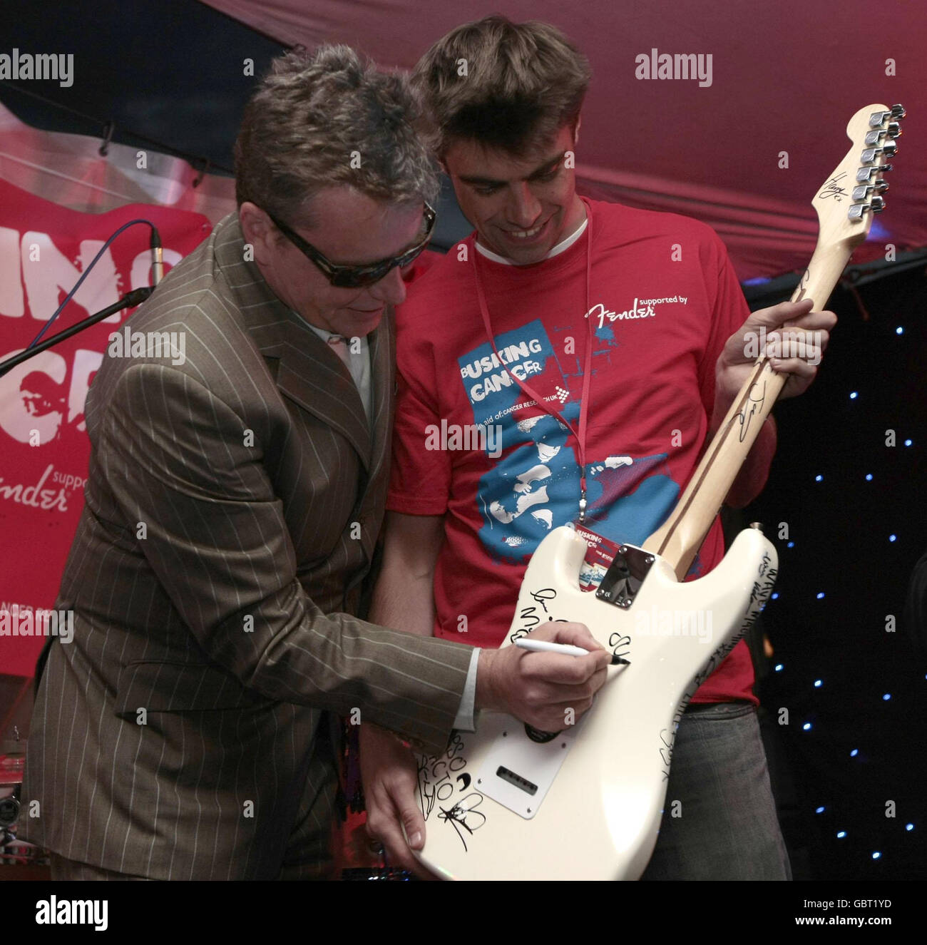 Madness singer Suggs adds his signature to a Fender guitar that has ...