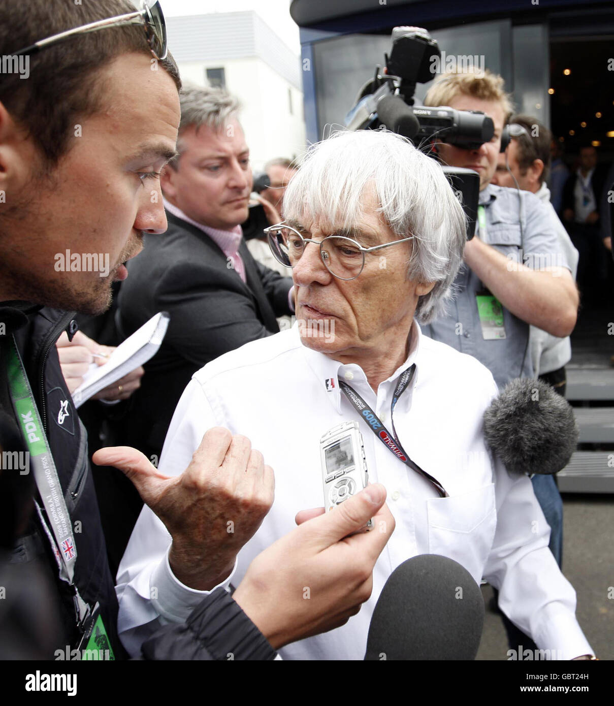President and CEO of Formula One Bernie Ecclestone, flanked by the ...