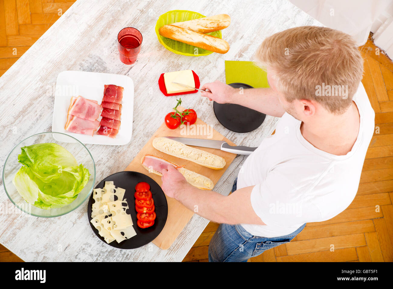 A young man preparing a sandwich in the kitchen Stock Photo - Alamy