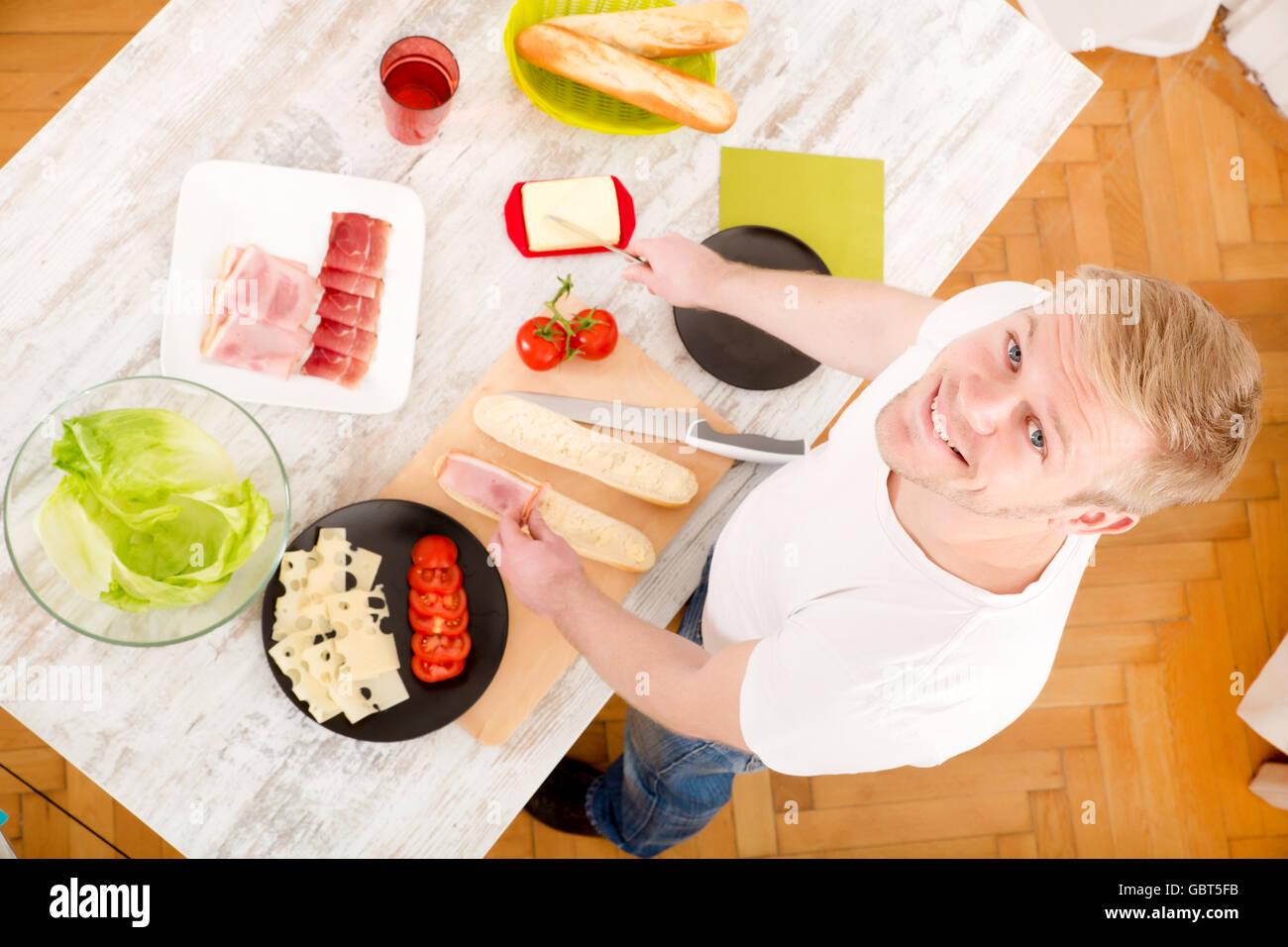 A young man preparing a sandwich in the kitchen Stock Photo - Alamy