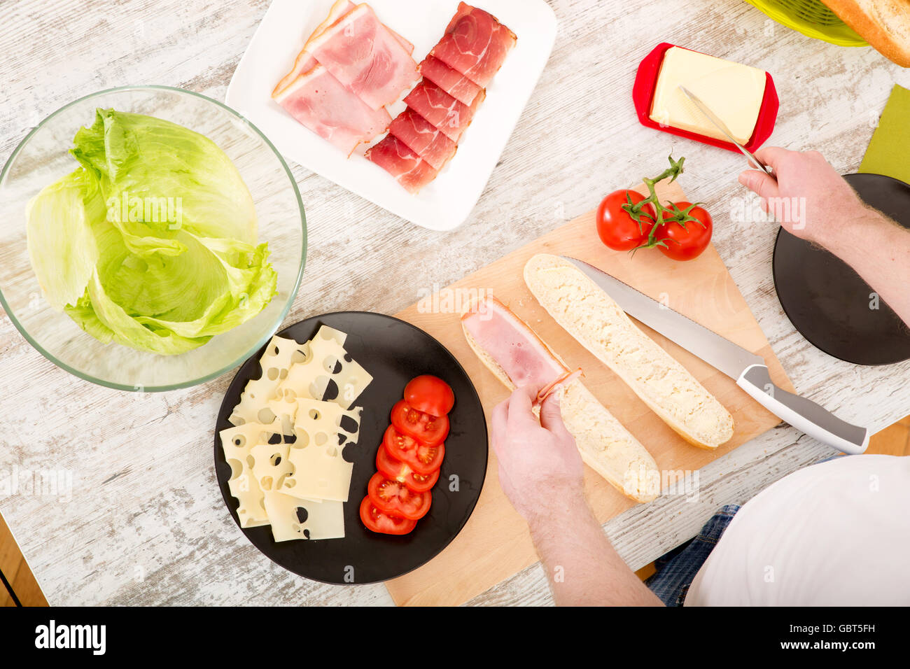 A young man preparing a sandwich in the kitchen Stock Photo - Alamy