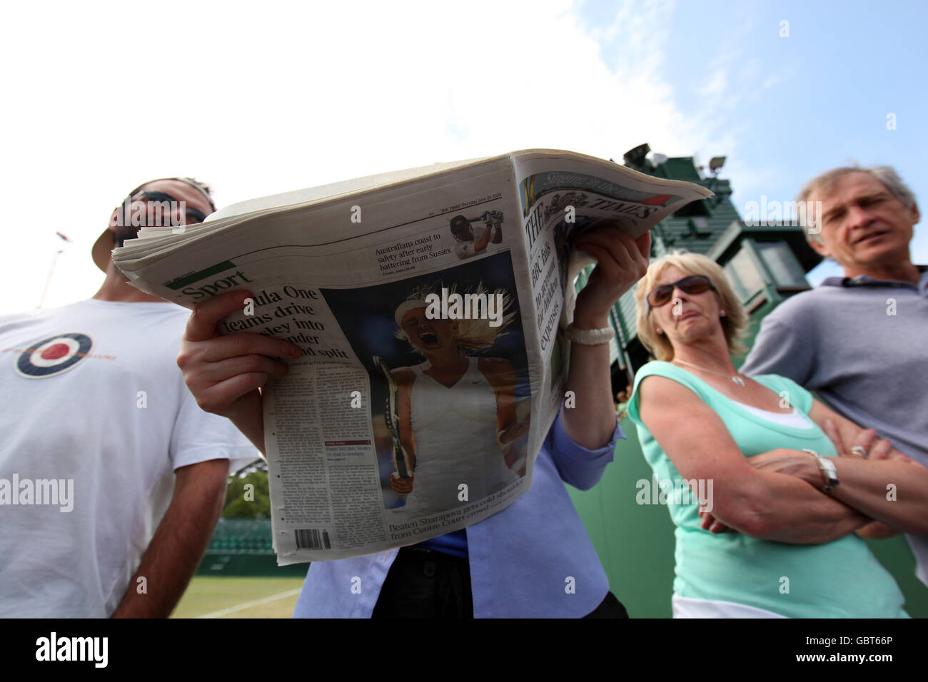 A spectators reads a newspaper during day 4 of the 2009 Wimbledon ...