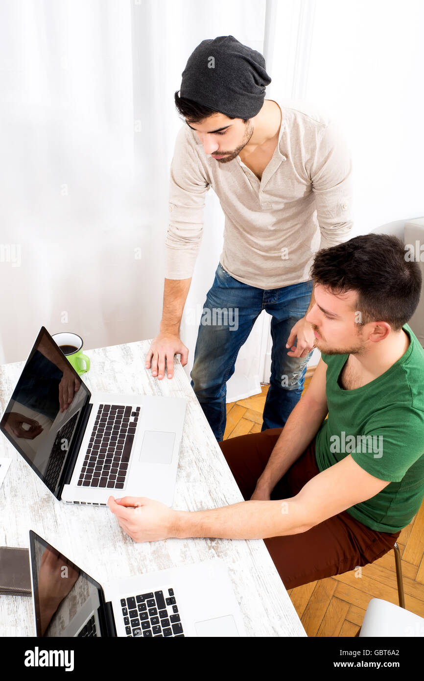 Two young colleagues discussing something in the office Stock Photo - Alamy