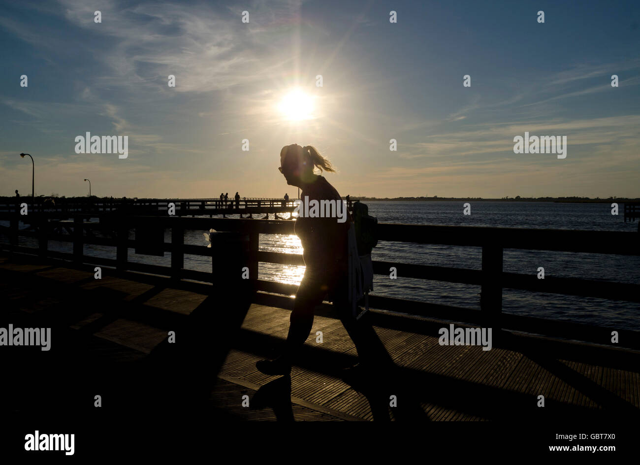 Woman walking on pier Stock Photo - Alamy