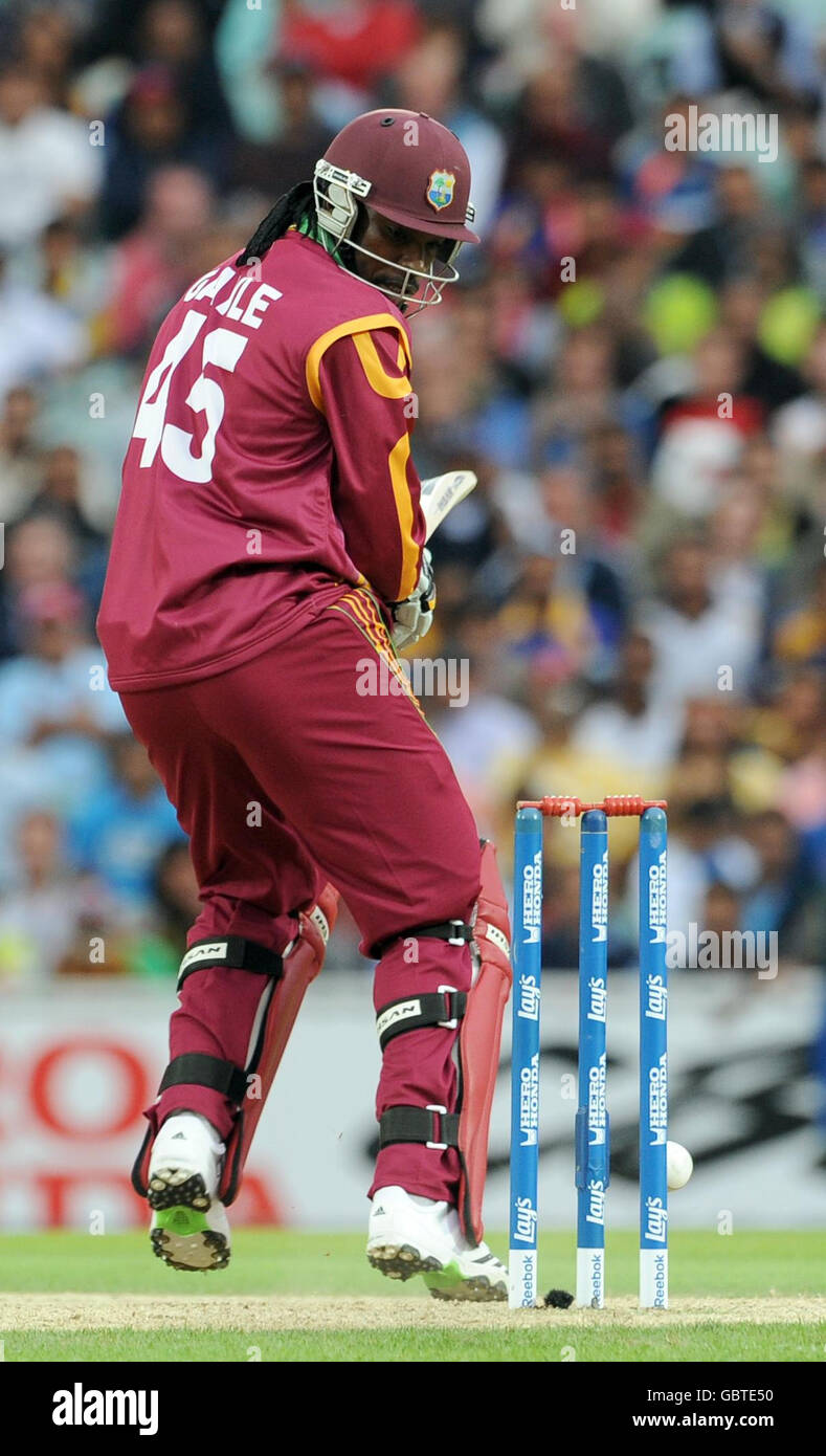 West Indies' Chris Gayle looks back as the ball hits his stumps but ...