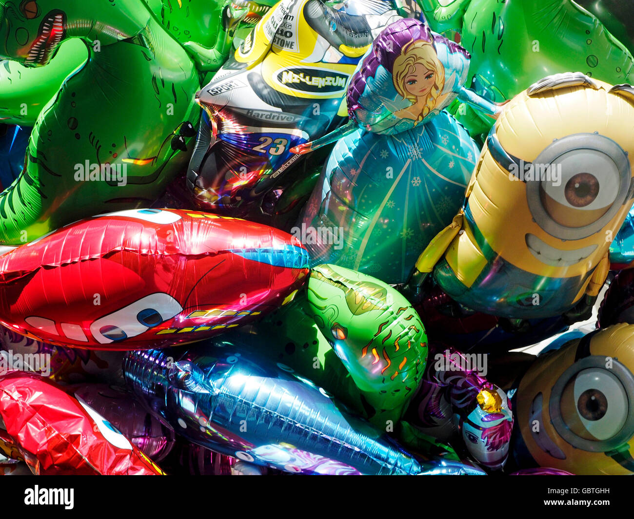 Brightly coloured helium filled balloons in the shape of cartoon film ...