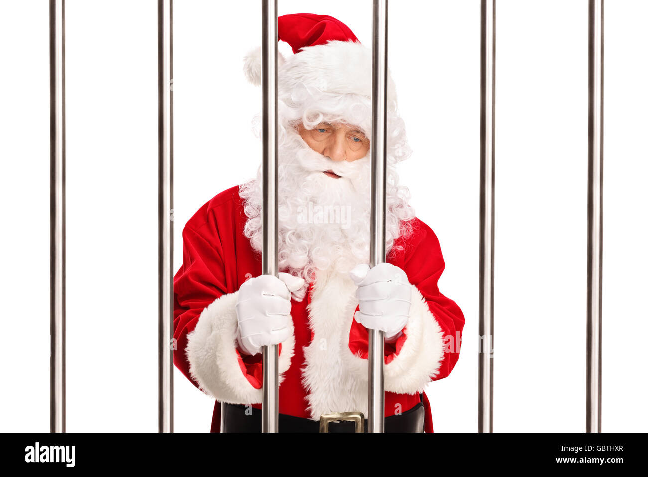 Mature criminal in a Santa Claus costume standing behind bars in a ...