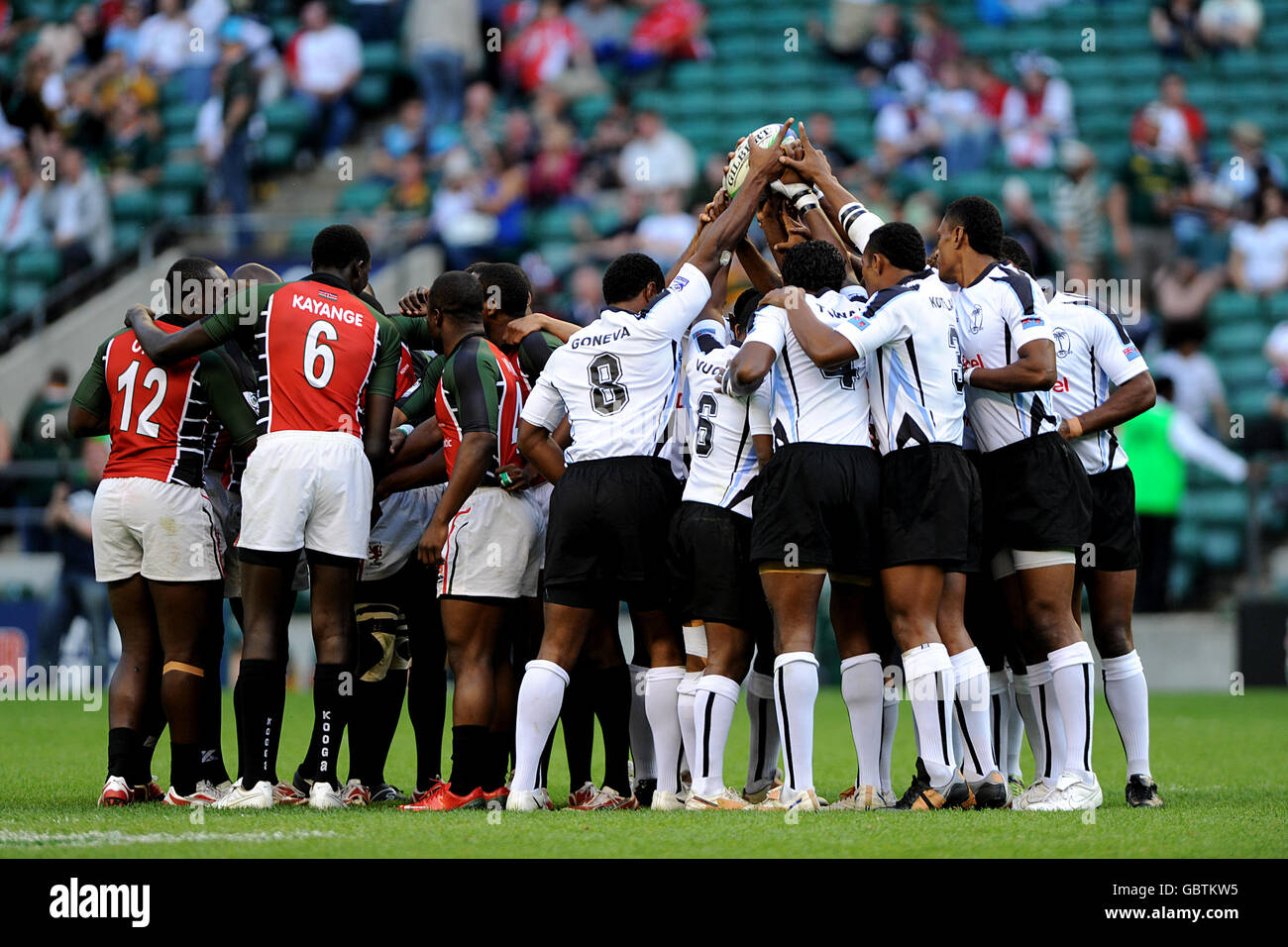 The Kenya team (left) and the Fiji team both huddle together for a team ...