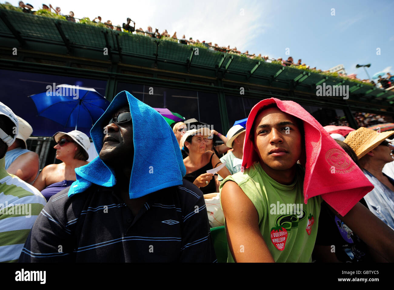 Tennis fans shelter from the sun on Court 18 during the Wimbledon ...
