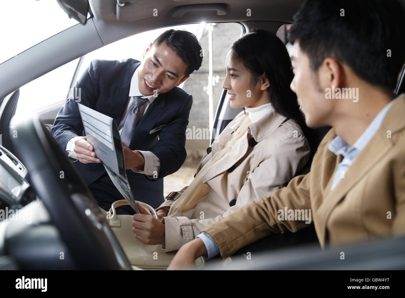 Car sales people and young couples Stock Photo - Alamy
