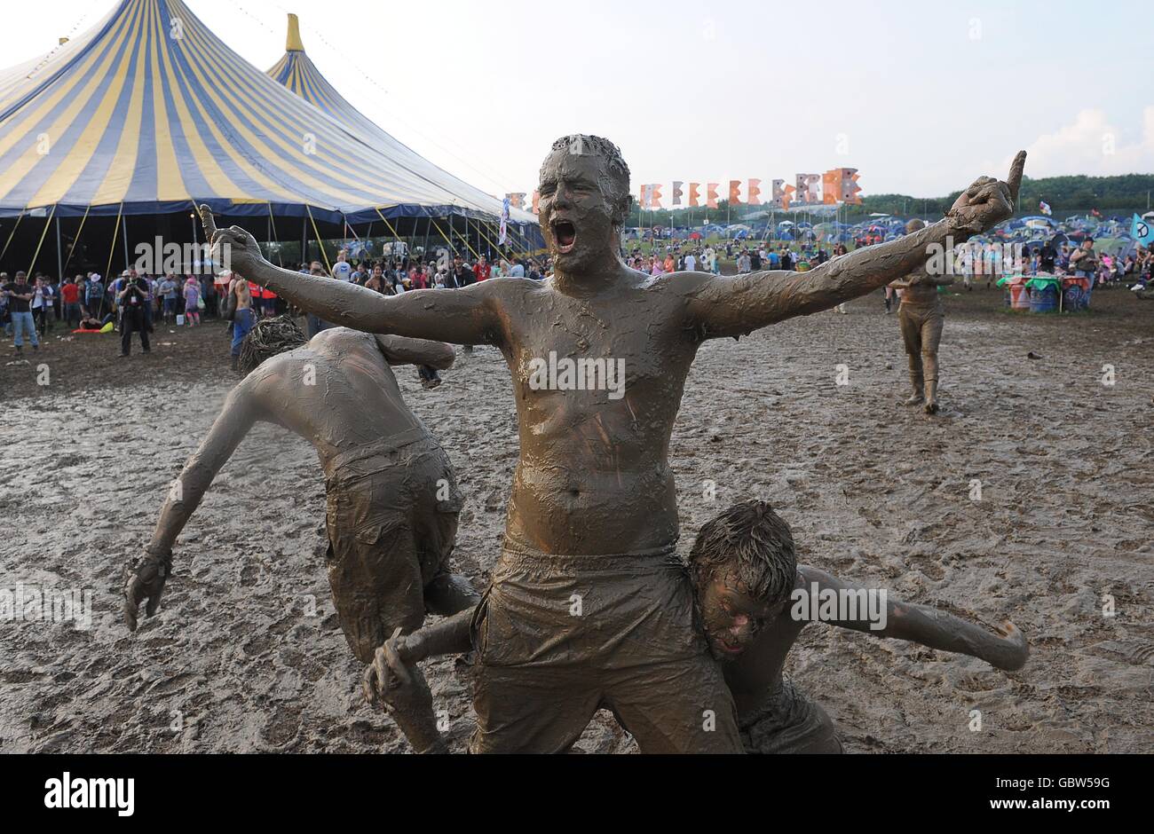 Festival goers covered in mud after a wrestling match during the 2009 ...