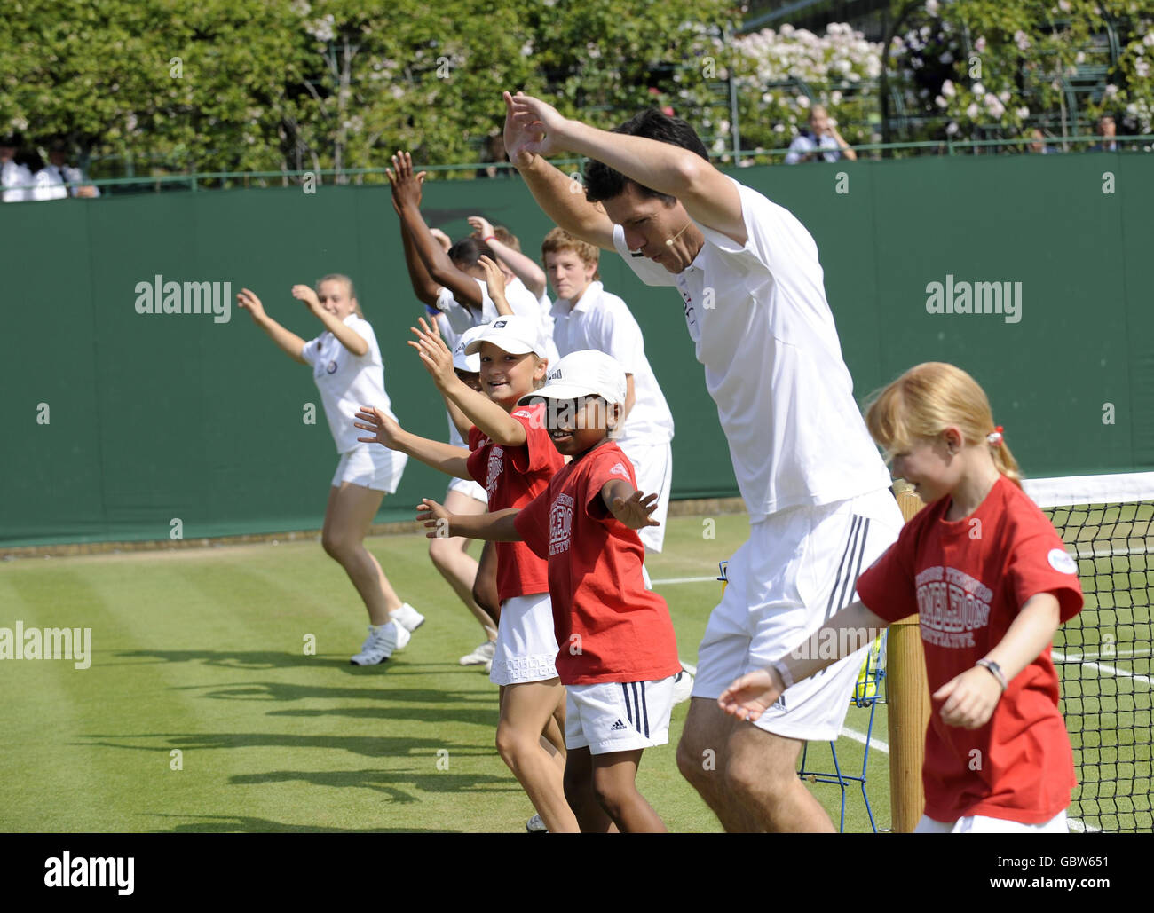 Tim Henman warms up with young children before a HSBC Sponsored ...