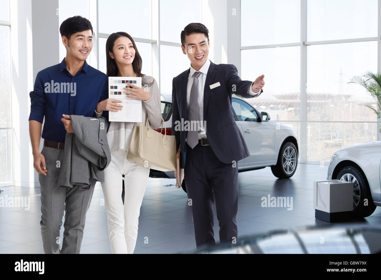 The young couple and car sales staff Stock Photo - Alamy