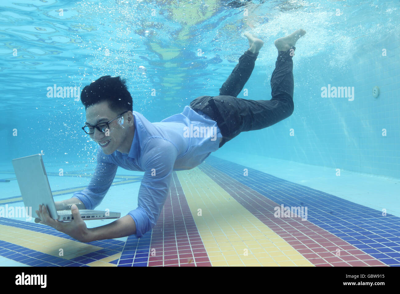 Young men use computers under water Stock Photo - Alamy