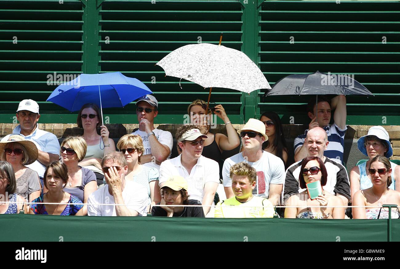 Spectators shade themselves from the sun during the Wimbledon ...