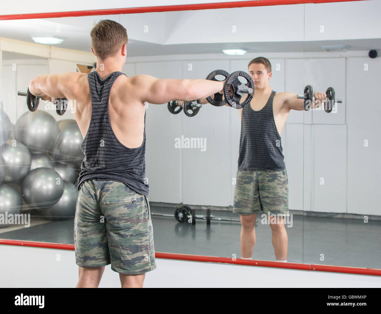 Man performing shoulders workout at the gym Stock Photo - Alamy