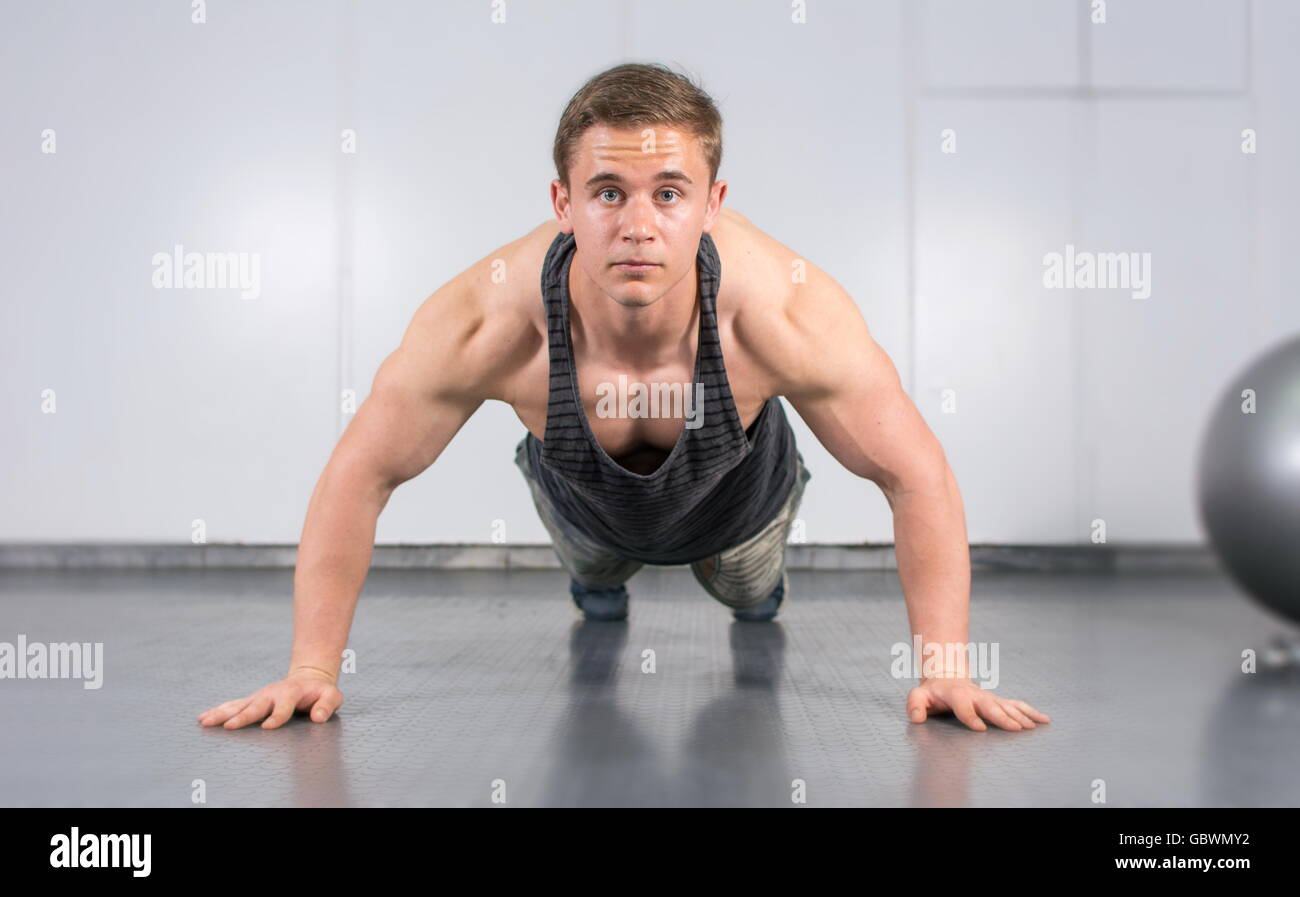 Young man performing push ups at the gym Stock Photo - Alamy