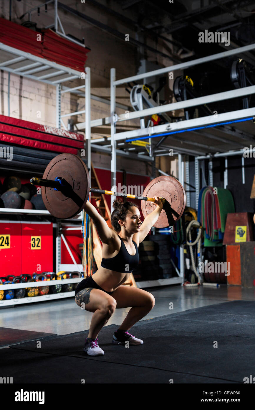 Strong woman working out with weight in gym Stock Photo - Alamy