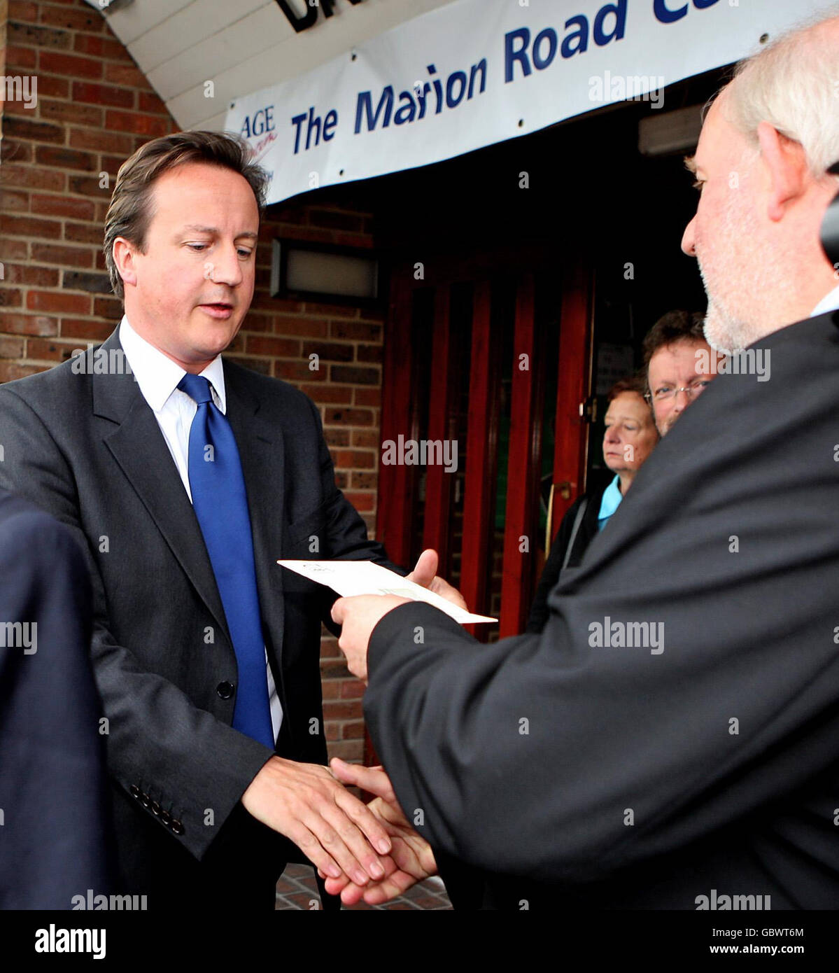 Leader of the Conservative Party David Cameron (left) is handed a ...