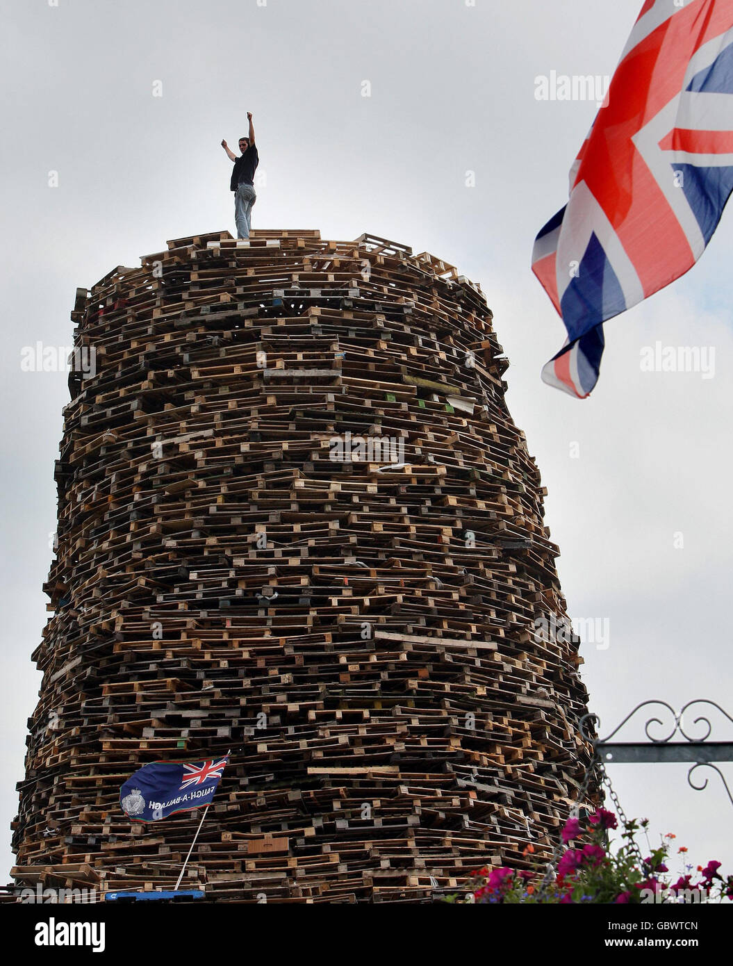 A man stands on top of a bonfire in Newtownabbey, outside Belfast ...