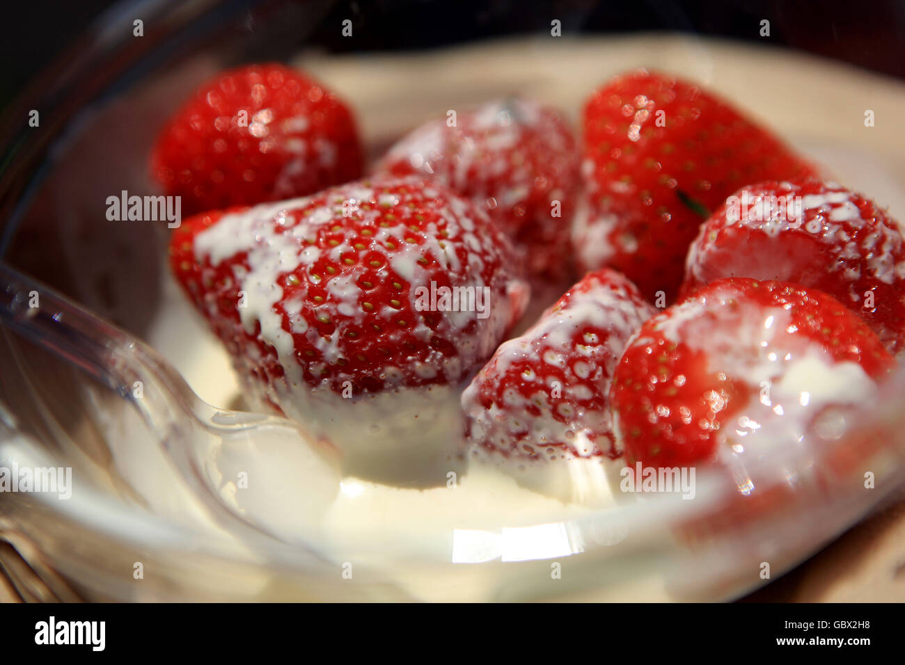 A fan eats some strawberries and cream during the Wimbledon ...