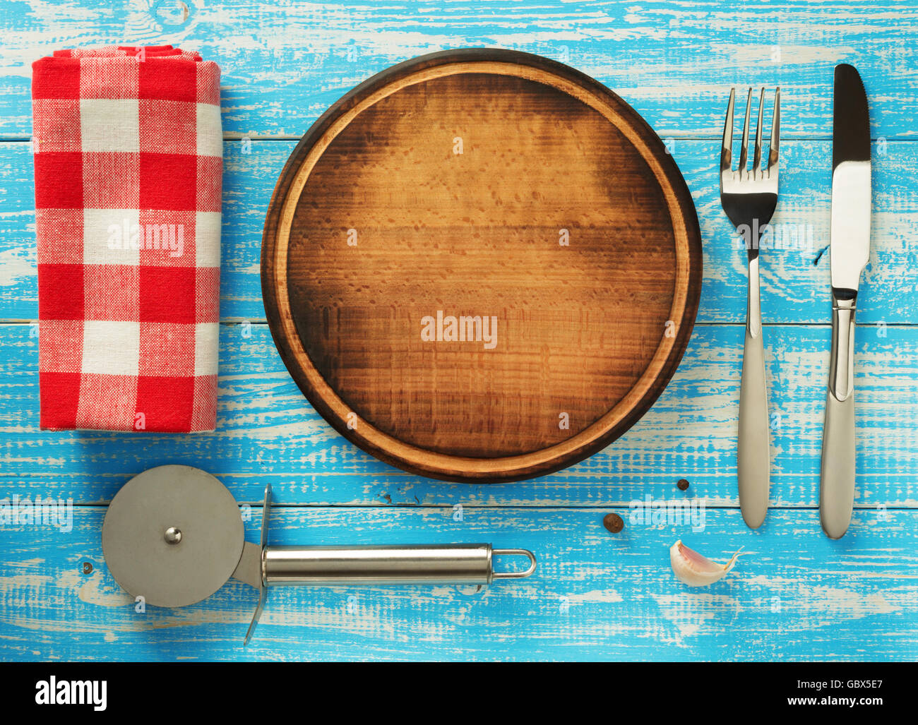 pizza cutting board and utensils at wooden table Stock Photo - Alamy