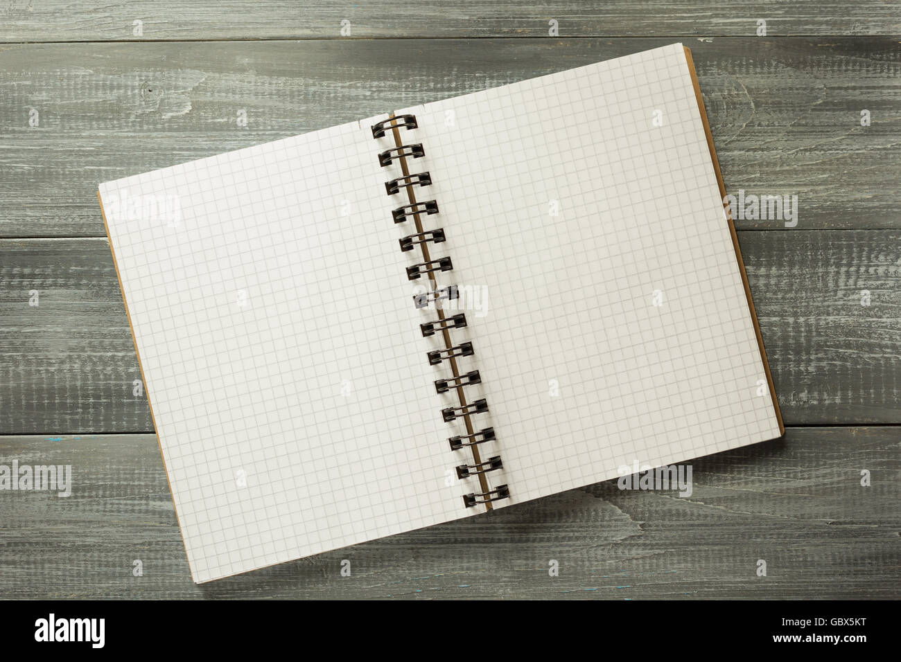 checked notebook on wooden background Stock Photo - Alamy