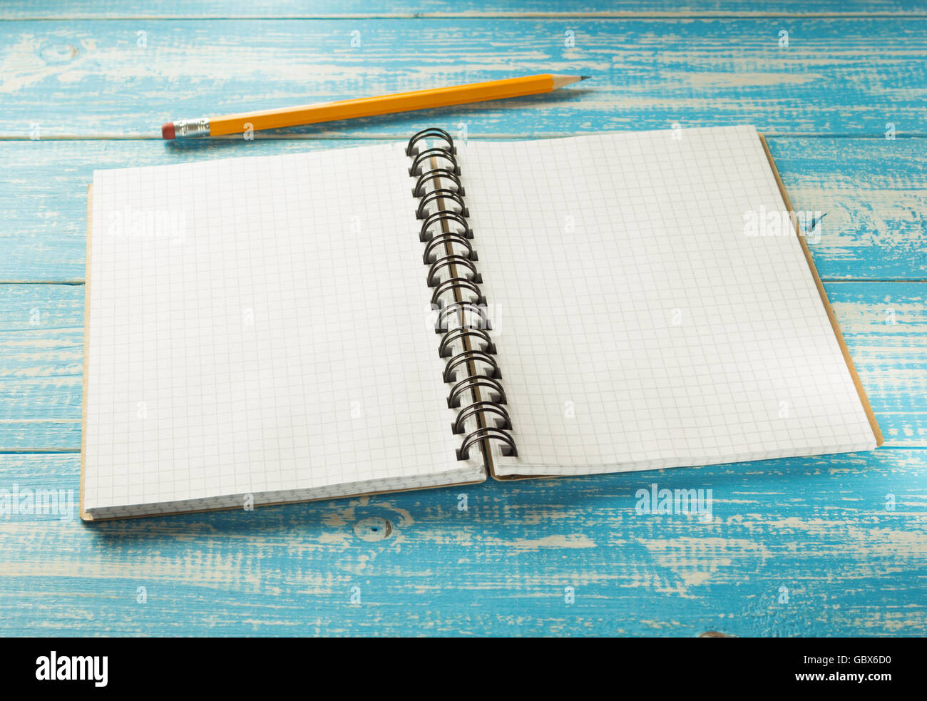 checked notebook on wooden background Stock Photo - Alamy