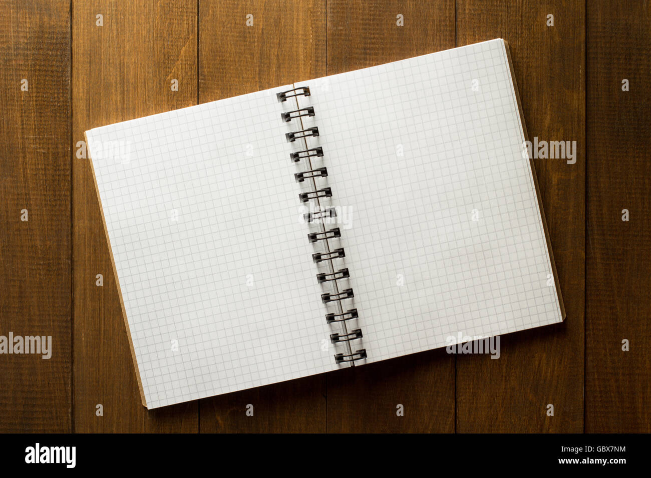 checked notebook on wooden background Stock Photo - Alamy