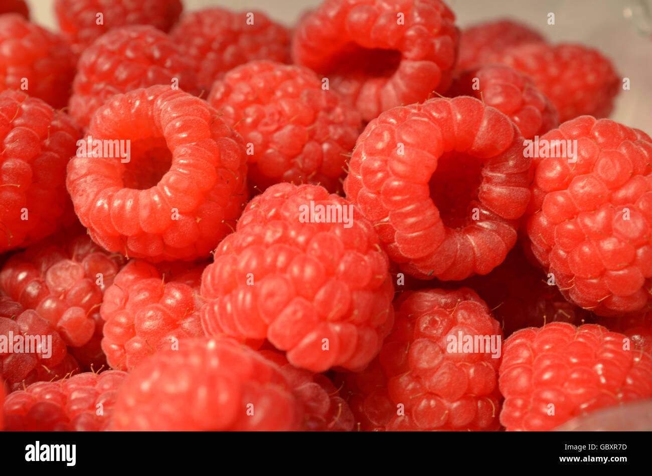 a heap of red raspberries in natural light Stock Photo - Alamy