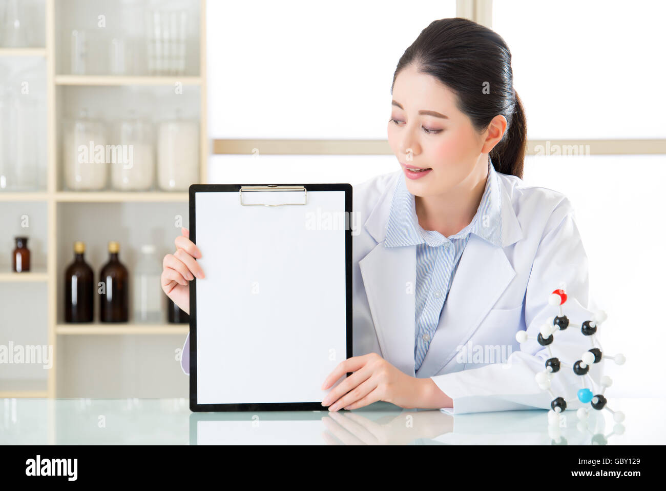 Happy asian female scientist holding clipboard and look at it with ...