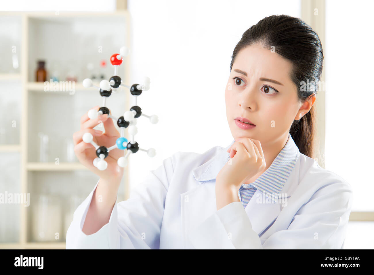 asian female scientist holding and looking at molecular model doing the ...