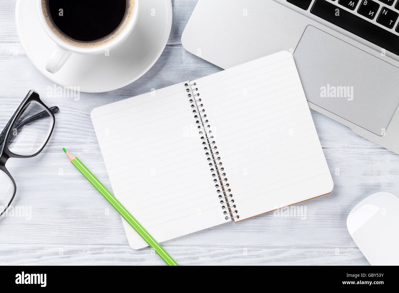 Desk table with notepad, laptop, coffee and sunglasses on wooden table ...