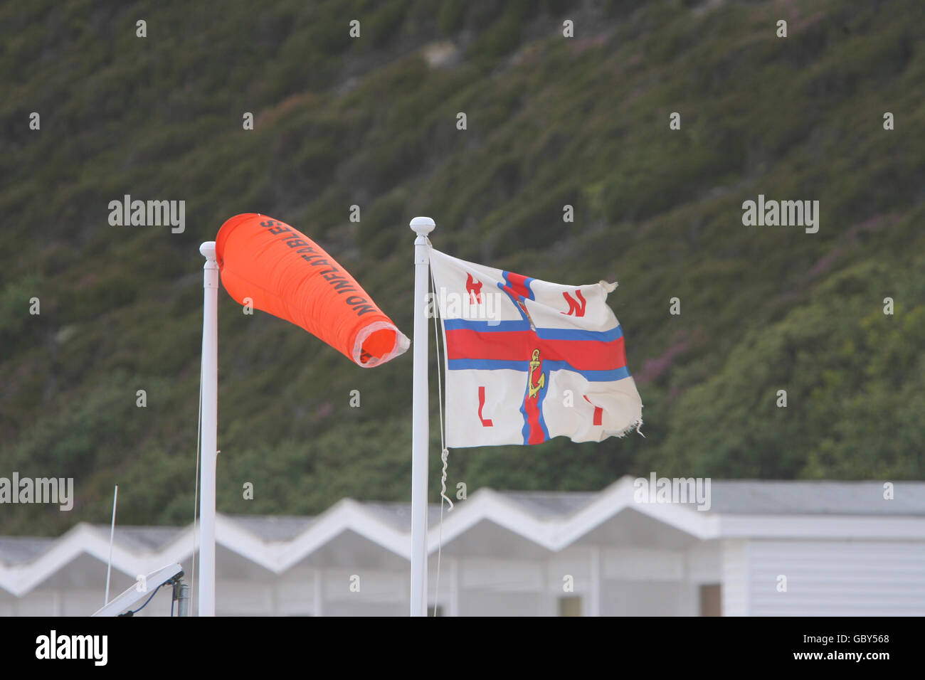 A warning sign flies next to the RNLI beach lifeguard station at ...