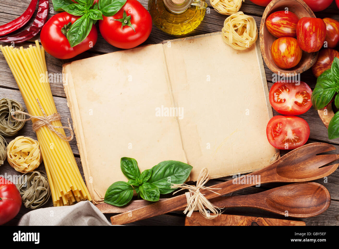 Italian food cooking. Tomatoes, basil, spaghetti pasta, olive oil and ...