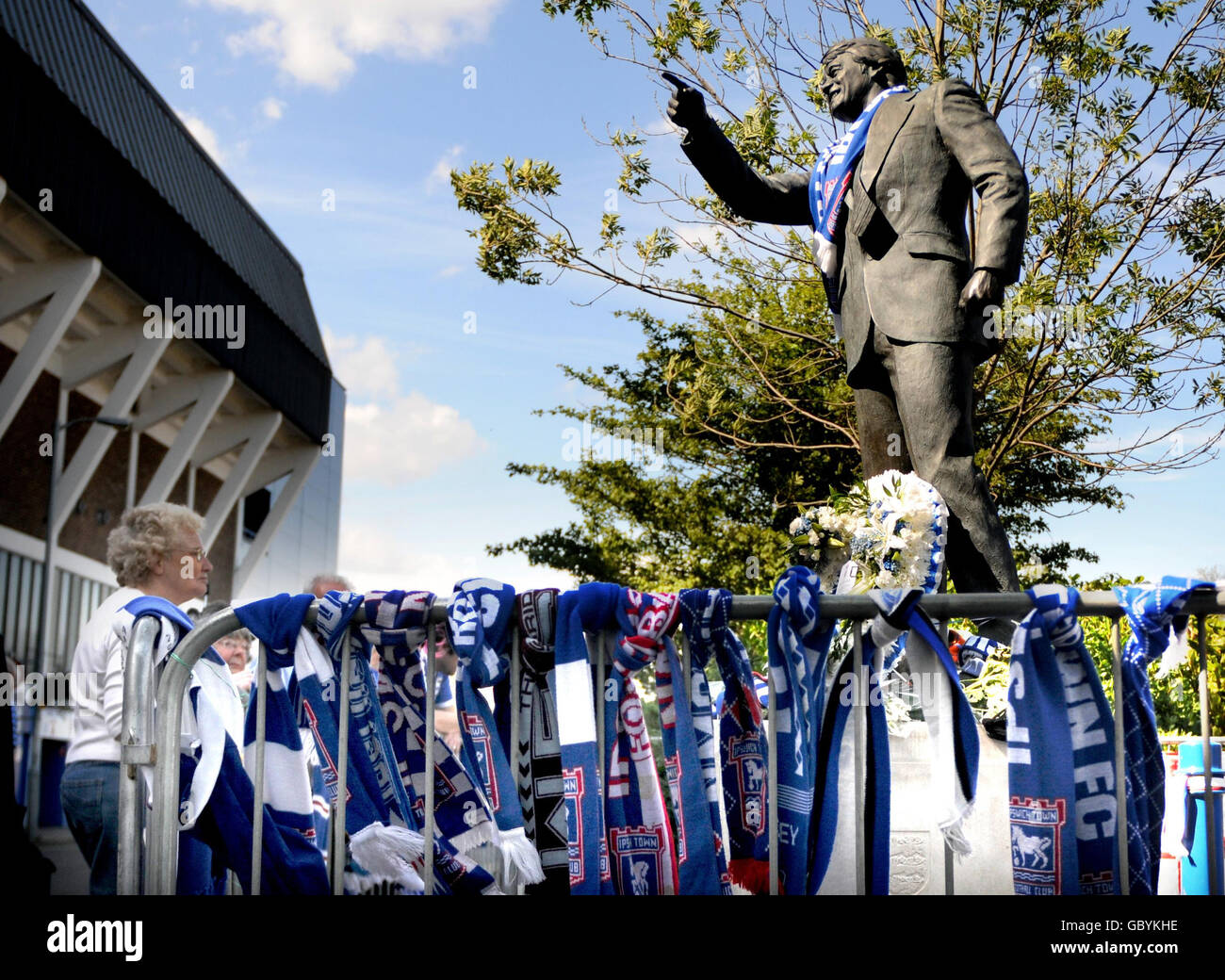 Floral tributes and scarves beside a statue of Bobby Robson outside ...