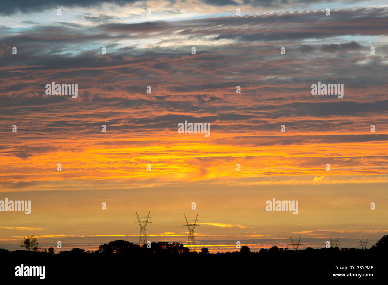 beautiful sunset over land with electricity poles Stock Photo - Alamy