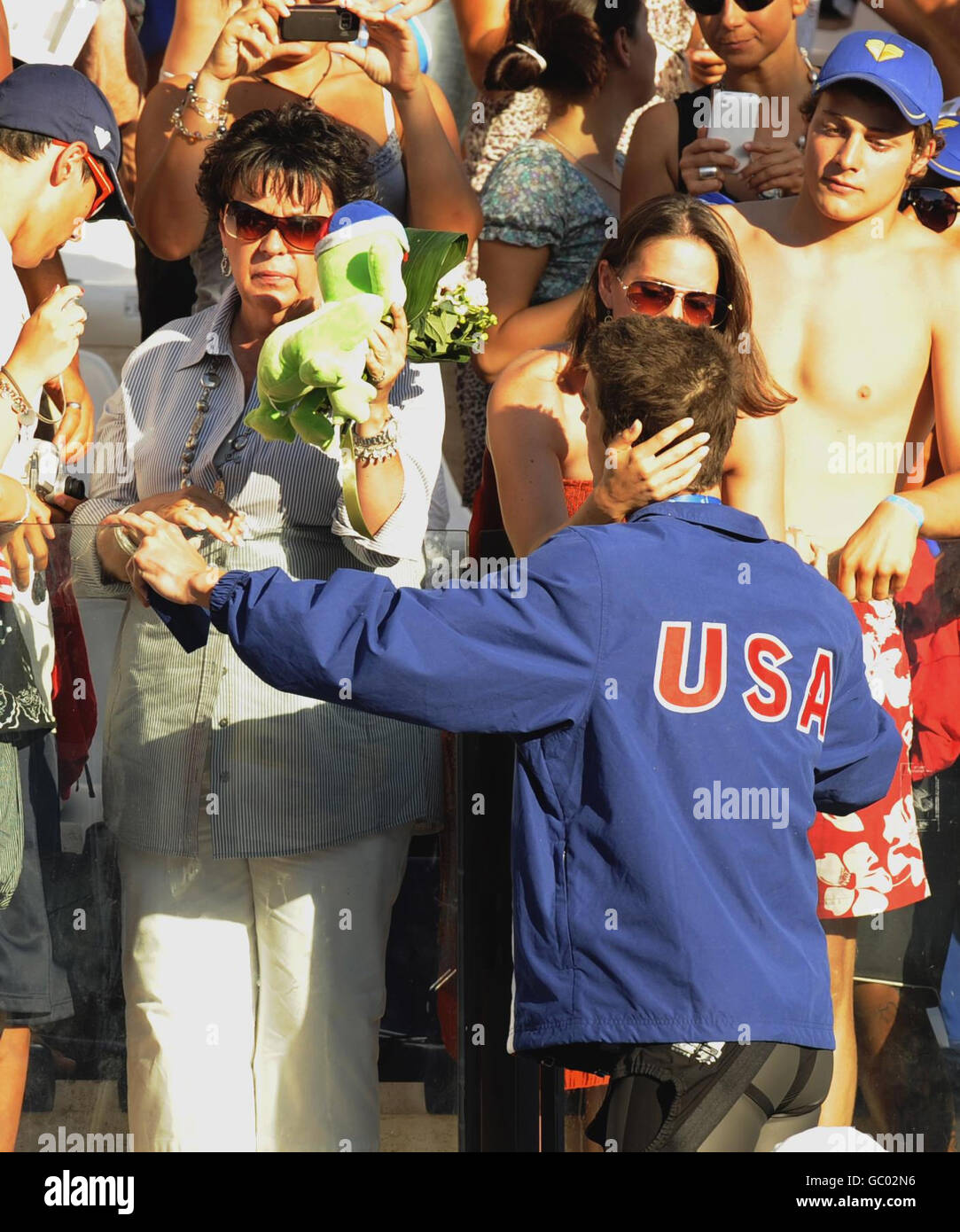 USA's Michael Phelps gives his mascot to his mother (left) and receives ...