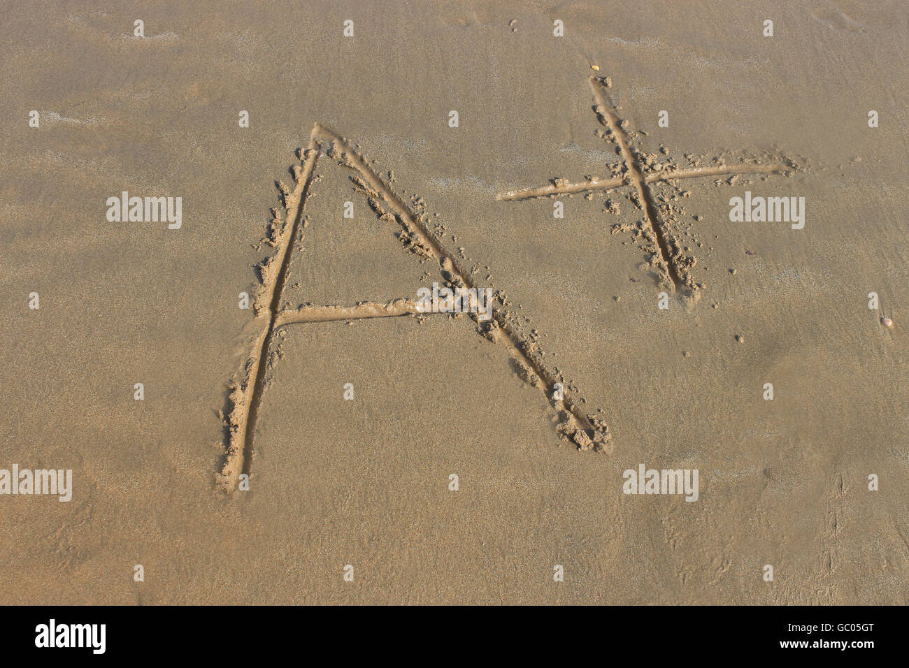A+ sign written on sandy beach Stock Photo - Alamy