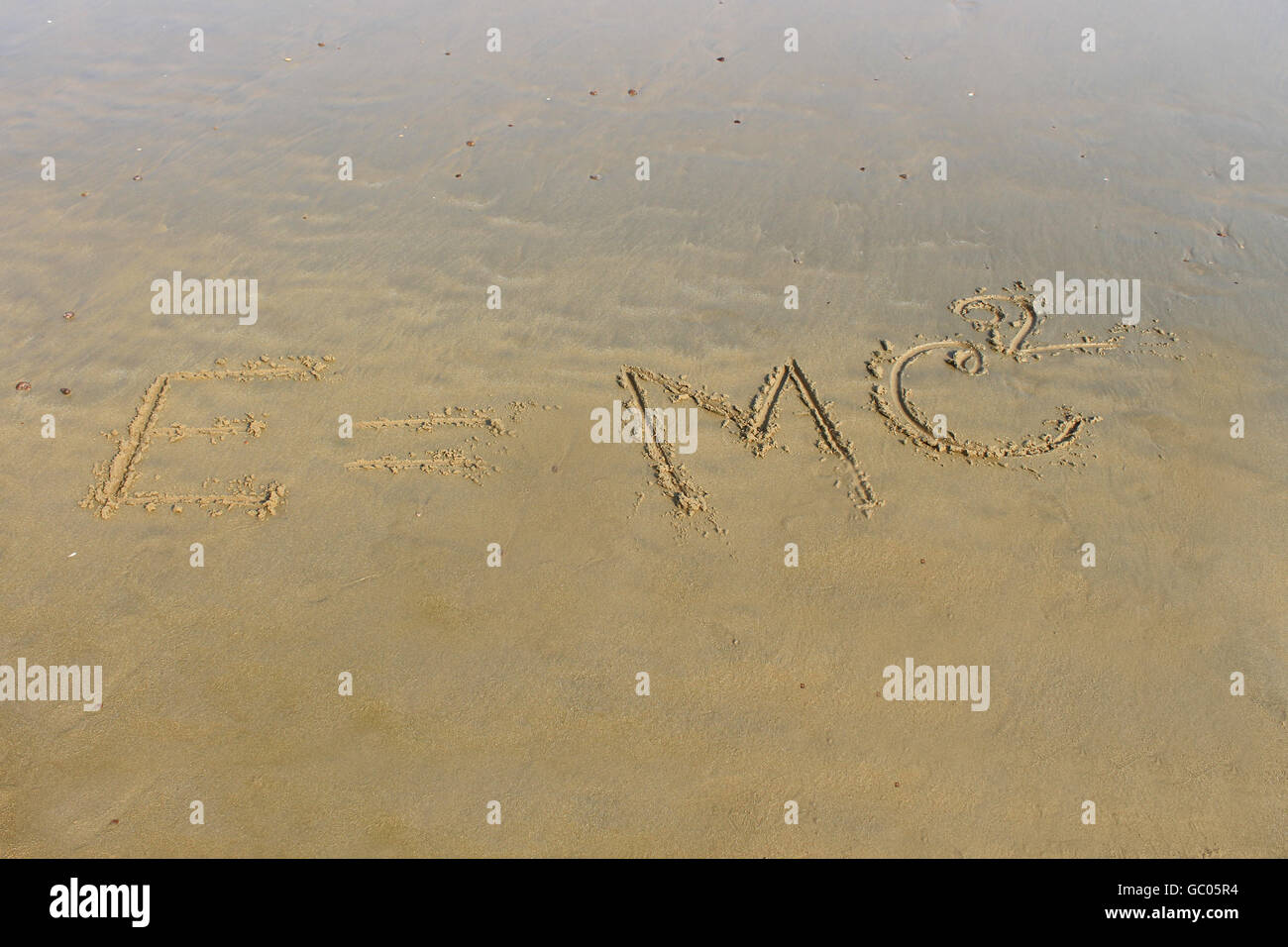 Albert Einstein formula E= mc2 written on sandy beach Stock Photo - Alamy