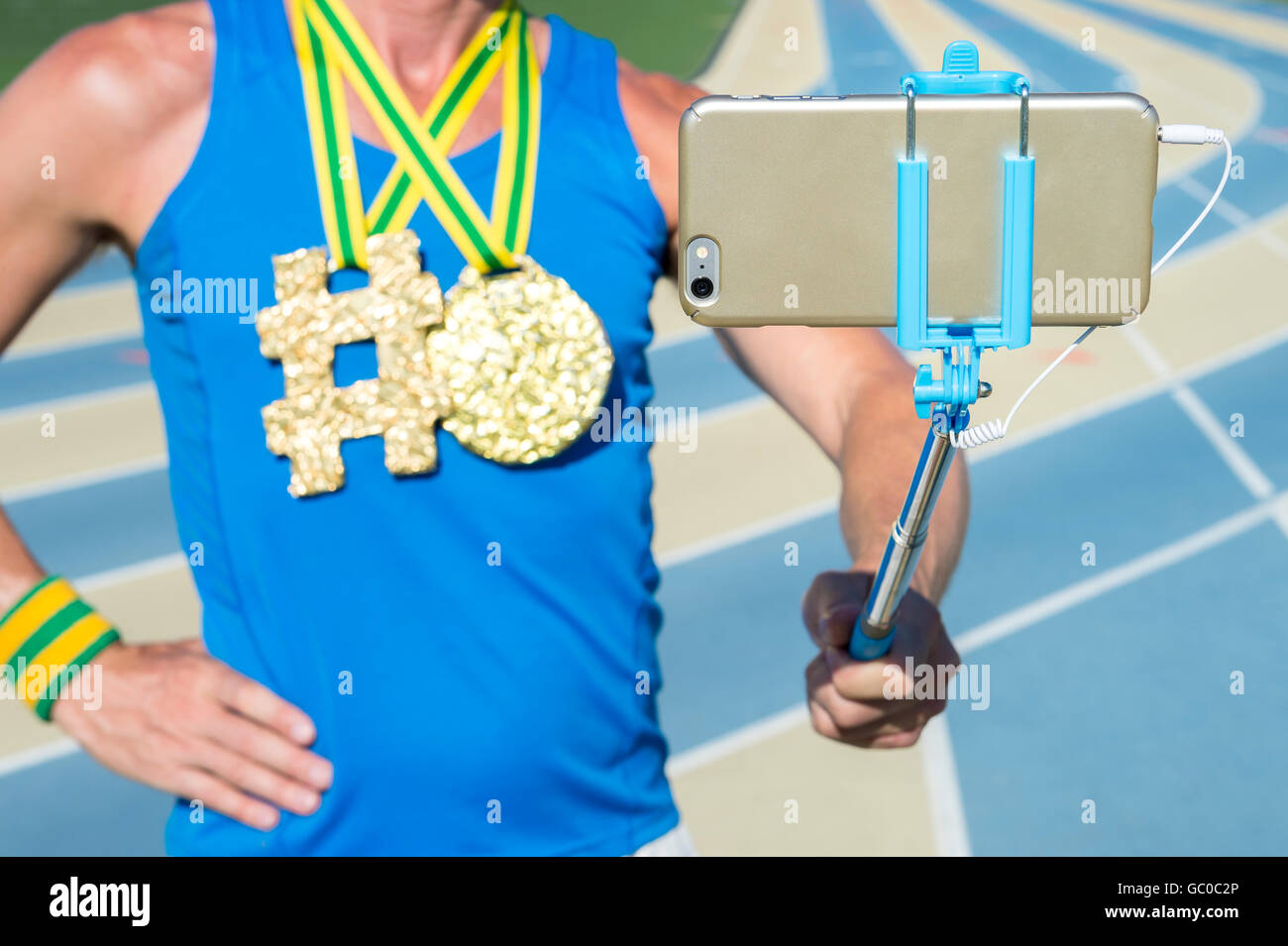 Hashtag gold medal athlete standing at running track taking a photo on ...