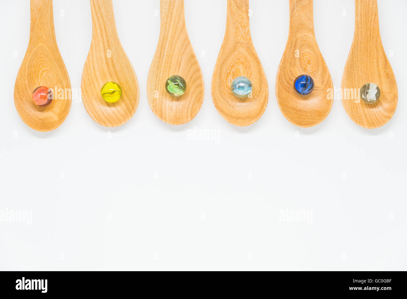 Seven Classic wooden spoon with colorful marble ball on white ...