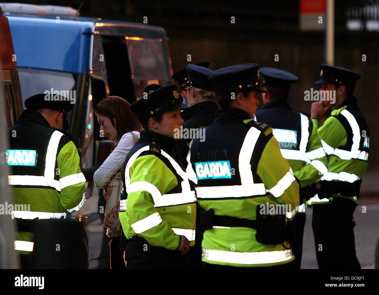 Gardai write down workers names (left) after taking them from the ...