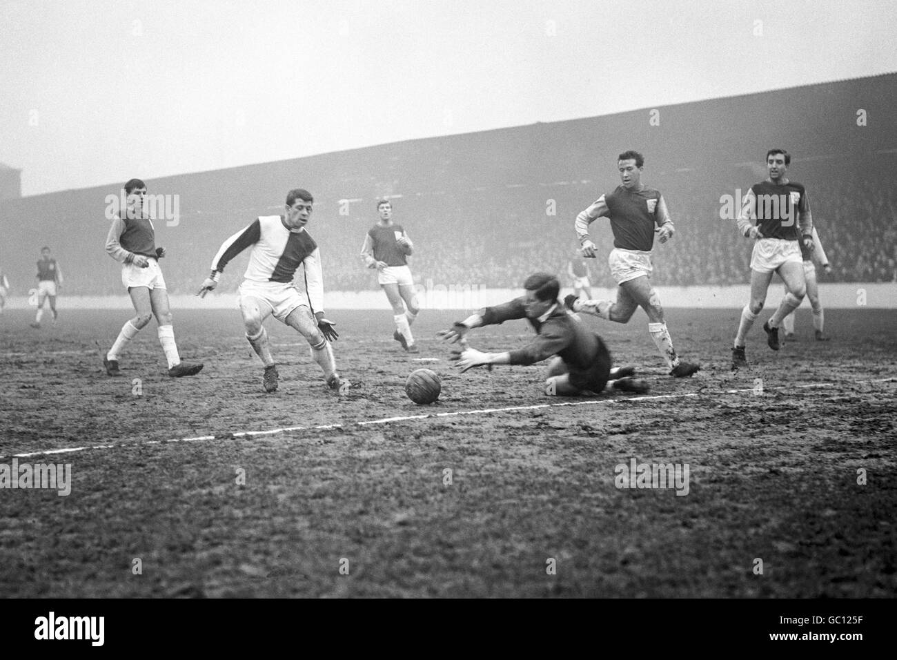 West Ham United goalkeeper Jim Standen (third r) dives at the feet of ...