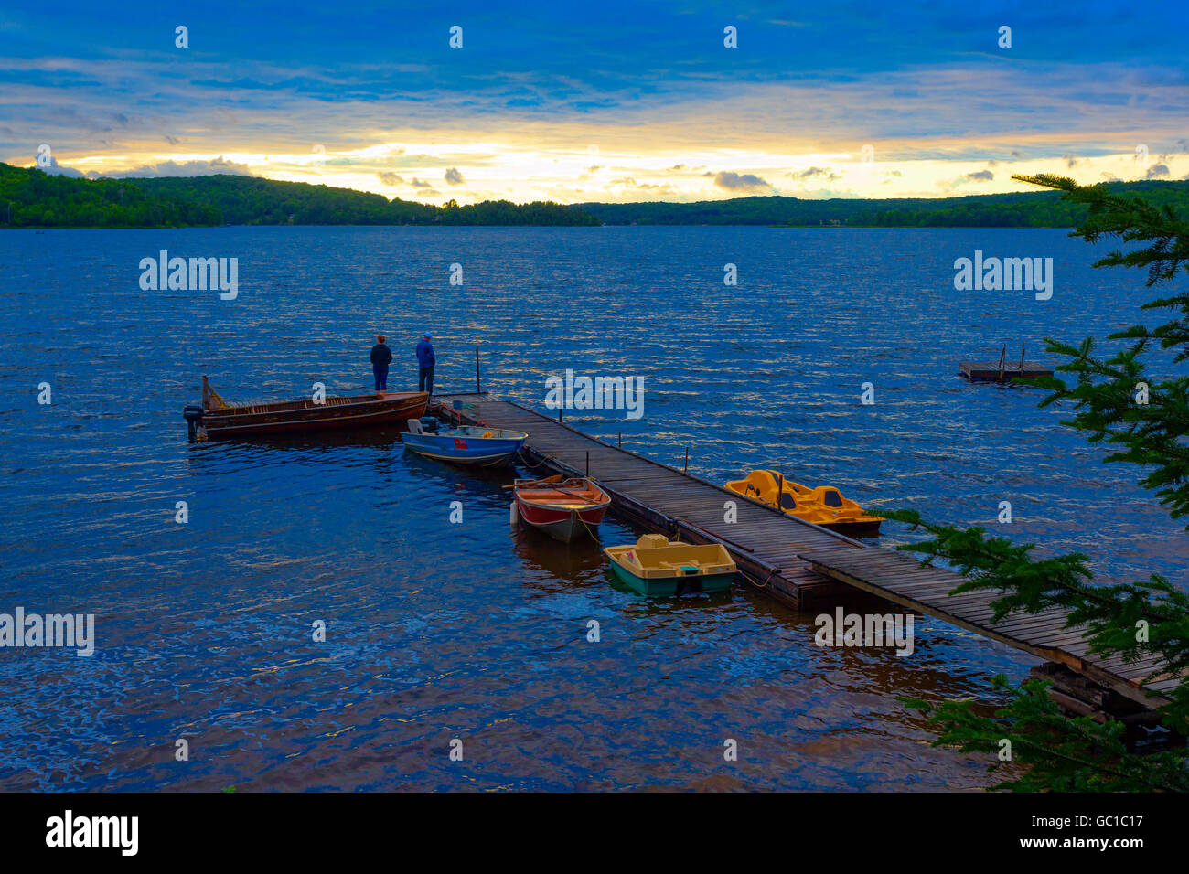 Two people on boat dock at Sunset in Northern Ontario Cottage Country ...